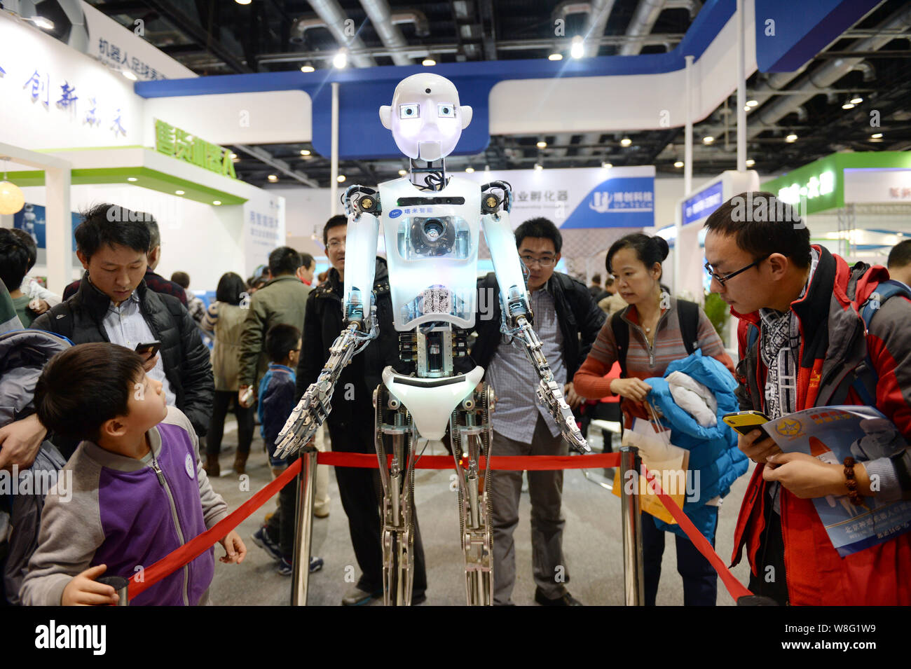 Visitors look at a robot of Tami Intelligence on display during the ...
