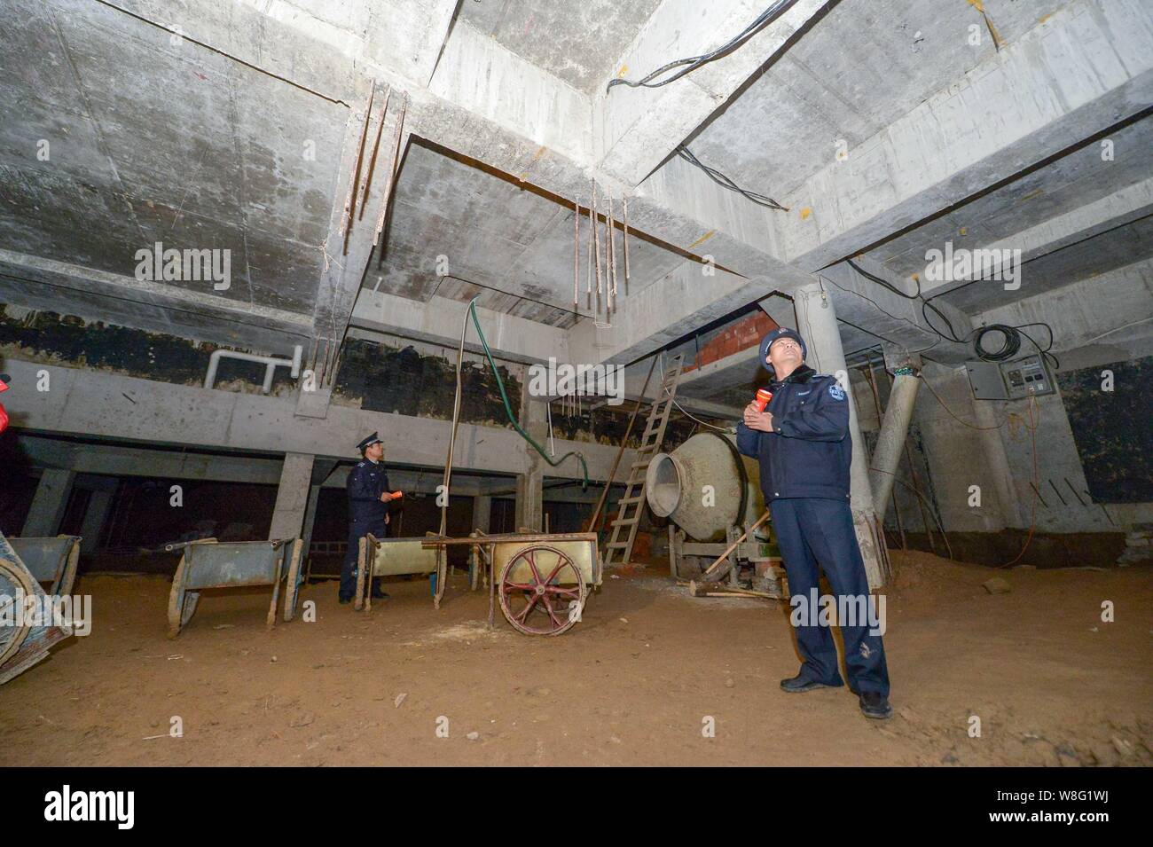 Chinese law enforcement officers check a three-level and 700-square ...