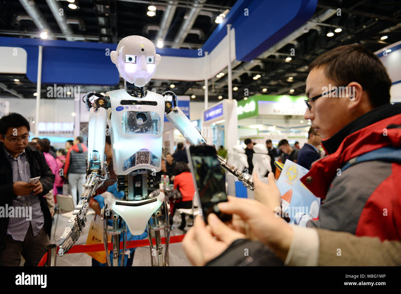Visitors look at a robot of Tami Intelligence on display during the ...