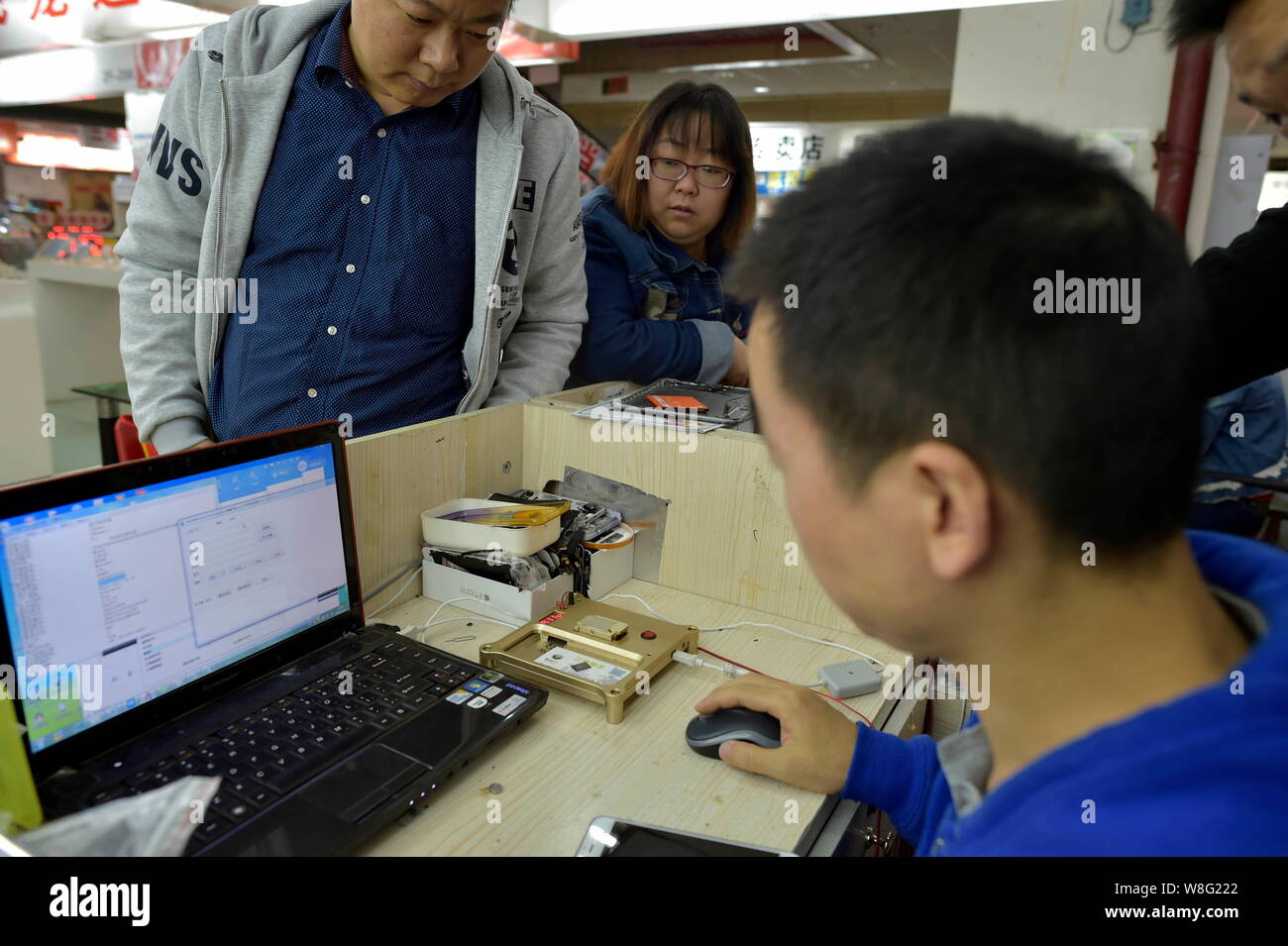 A Chinese technician operates his laptop computer to control a code ...