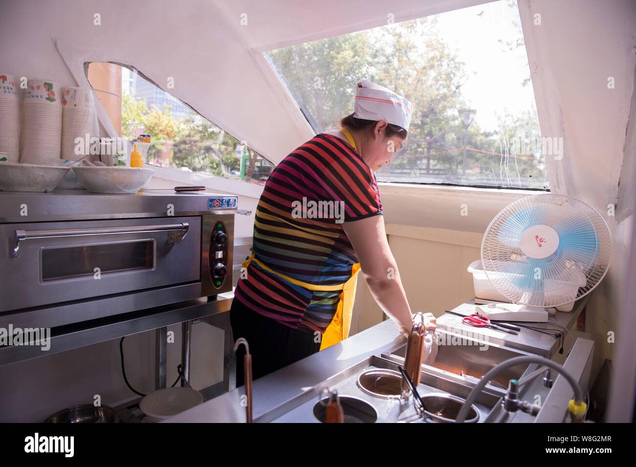 A woman cooks snacks inside the CRH (China Railway High-speed) train ...