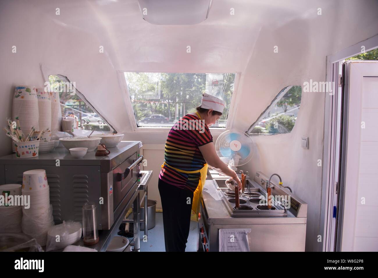 A woman cooks snacks inside the CRH (China Railway High-speed) train ...