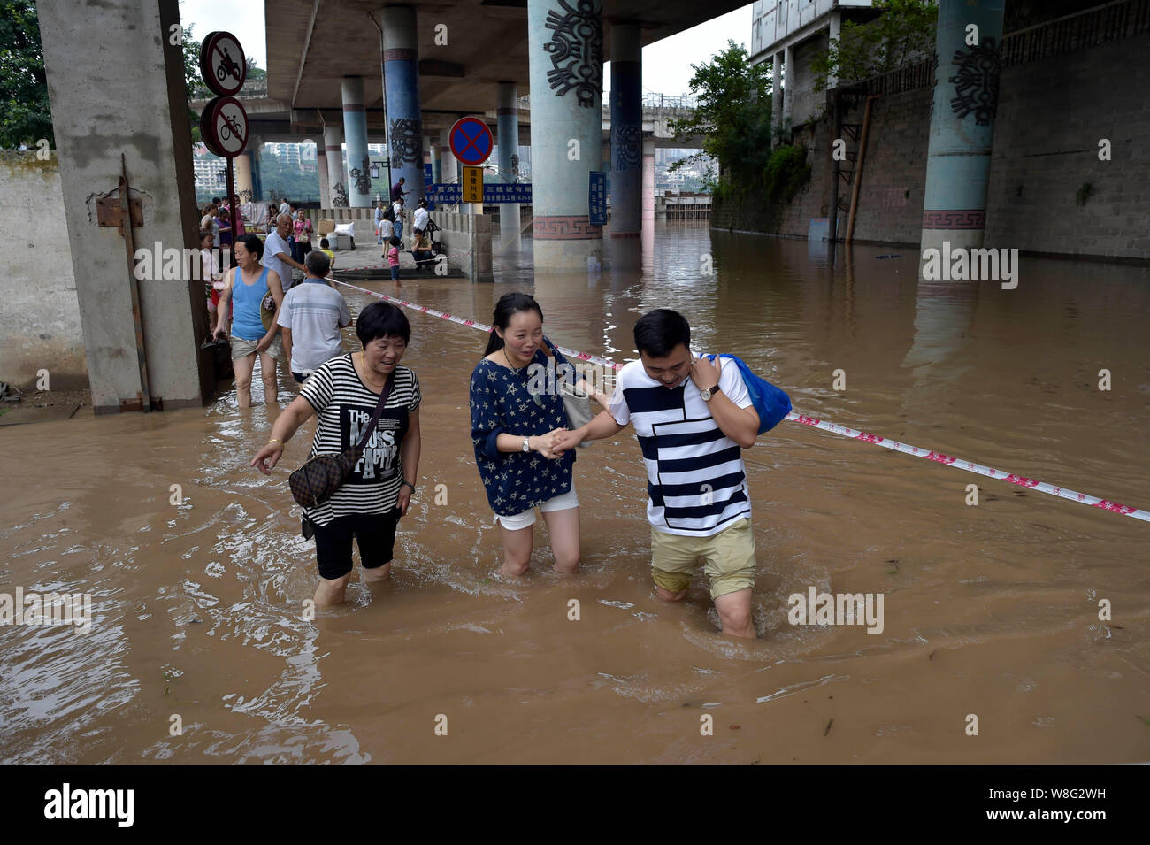 Pedestrians walk in flood caused by heavy rain in Chongqing, China, 30 ...