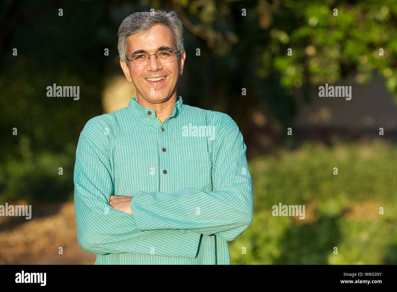 Old man smiling with his arms crossed Stock Photo - Alamy