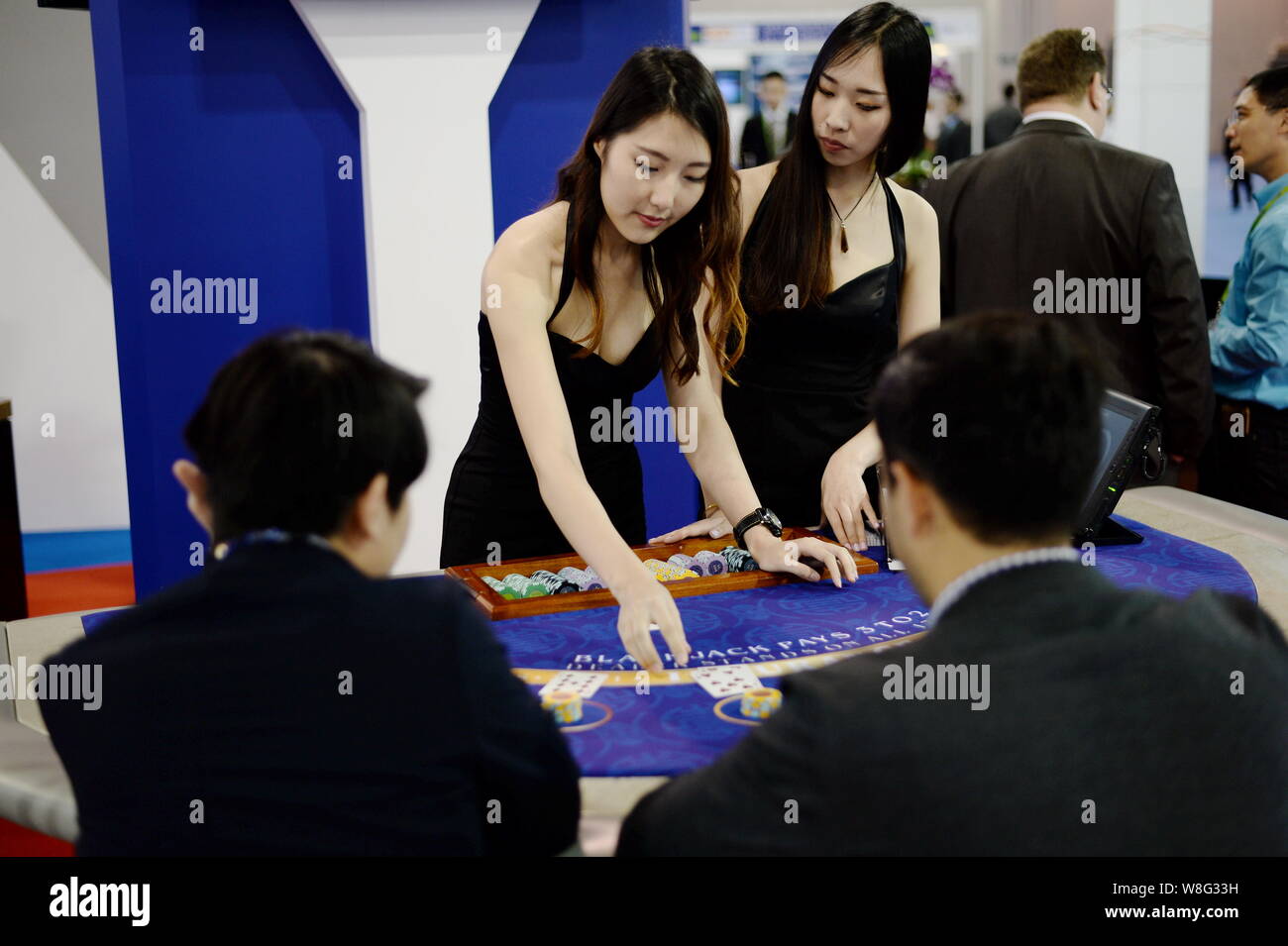 Hostesses gamble with visitors during the Global Gaming Expo (G2E) Asia ...