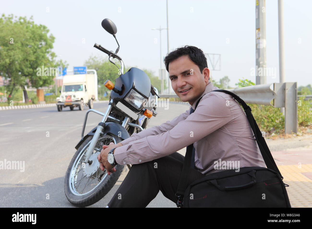 Sales executive waiting at roadside with his motorcycle Stock Photo - Alamy