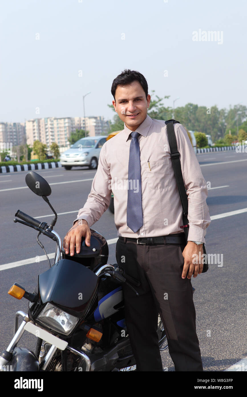 Sales executive waiting at roadside with his motorcycle Stock Photo - Alamy