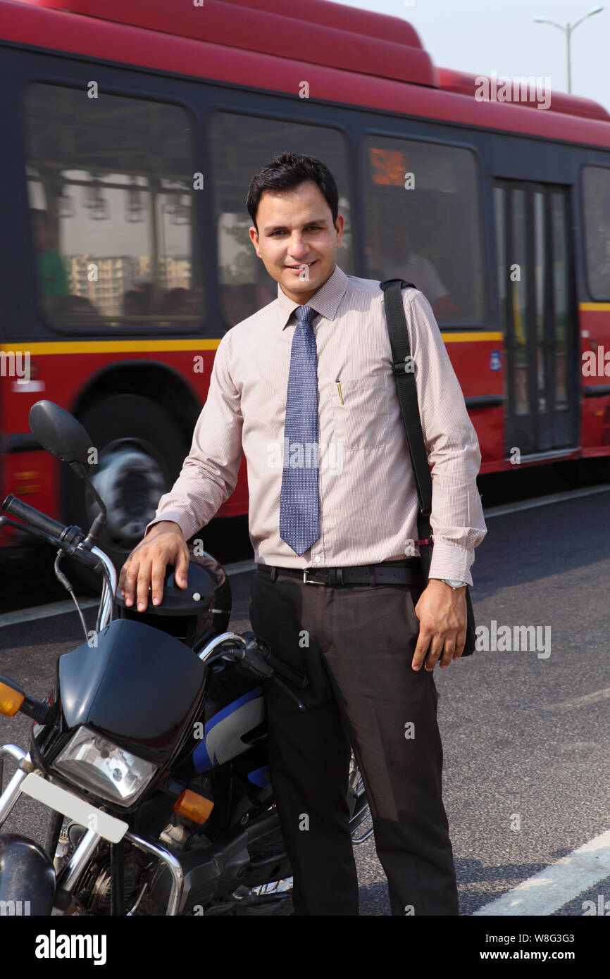 Sales executive waiting at roadside with his motorcycle Stock Photo - Alamy