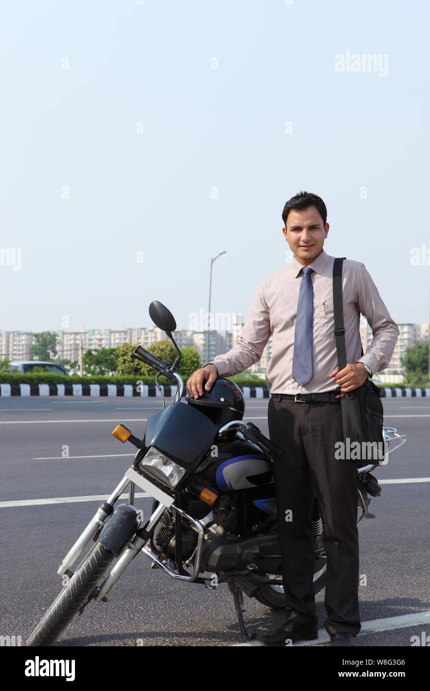 Sales executive waiting at roadside with his motorcycle Stock Photo - Alamy