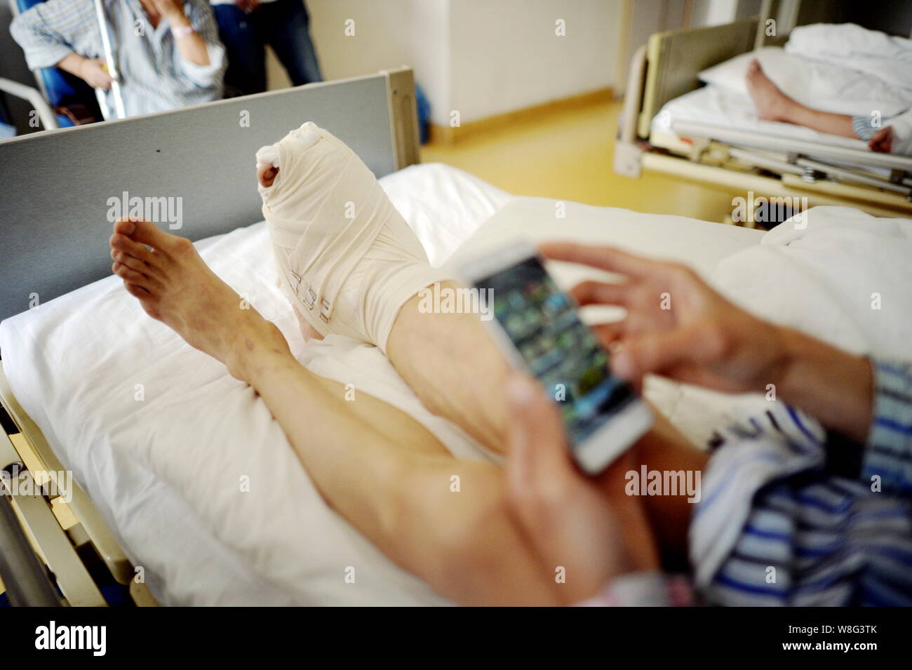 Liu Huichang who suffers from local gigantism uses his smartphone on ...