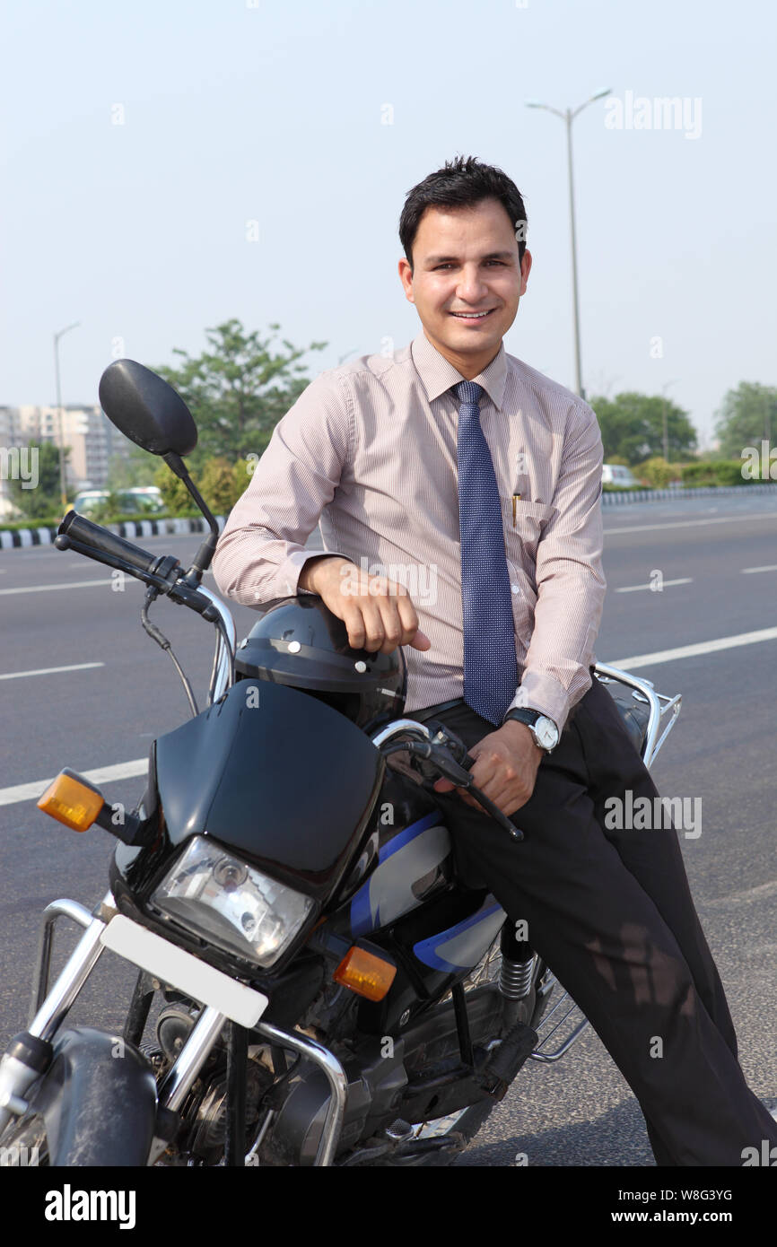 Sales executive waiting at roadside with his motorcycle Stock Photo - Alamy