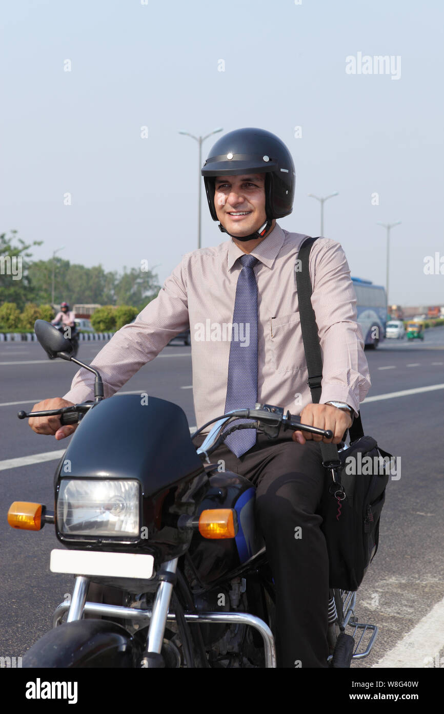 Sales executive riding a motorcycle Stock Photo - Alamy
