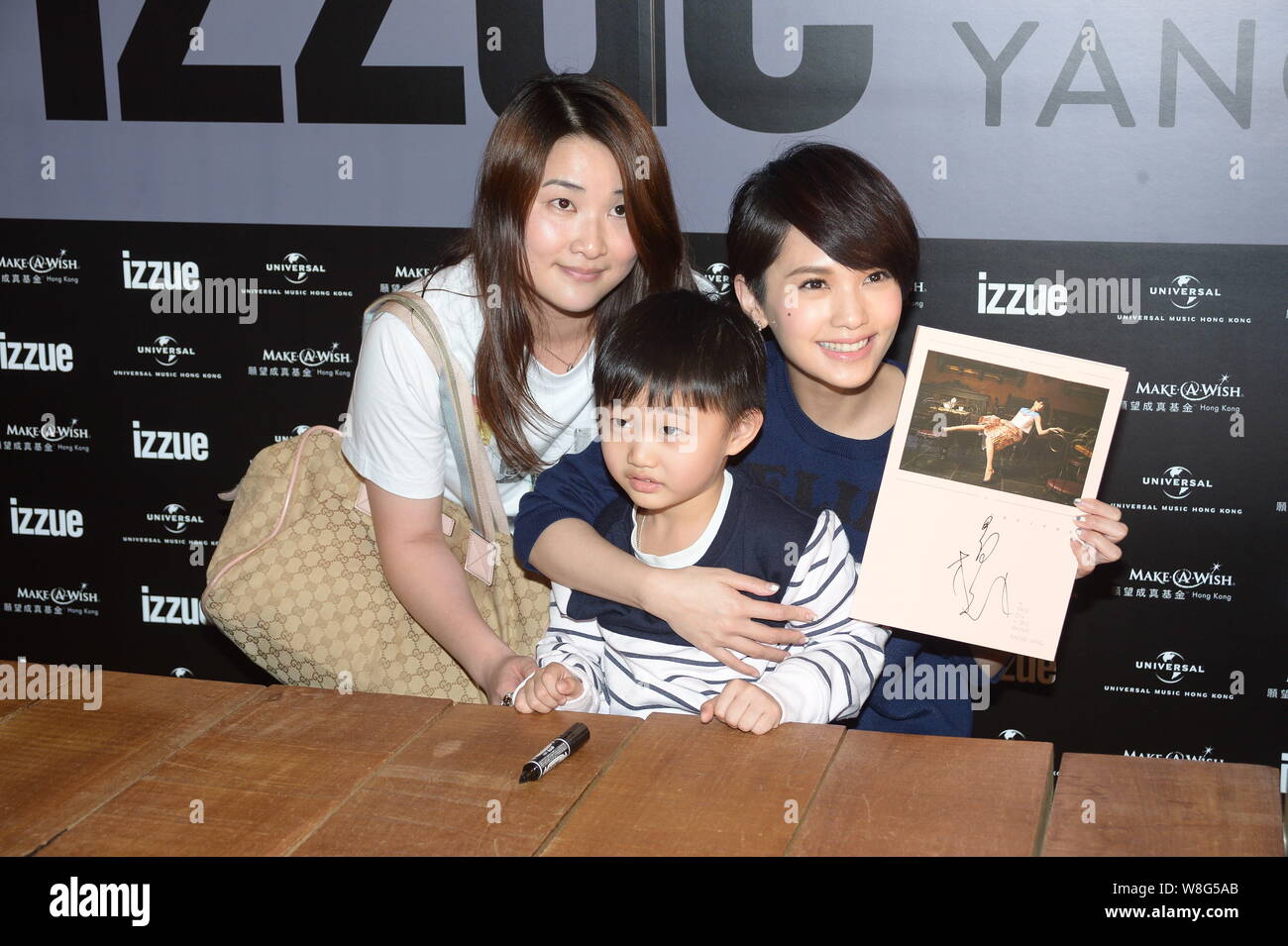 Taiwanese singer Rainie Yang, right, poses with a young boy and his ...