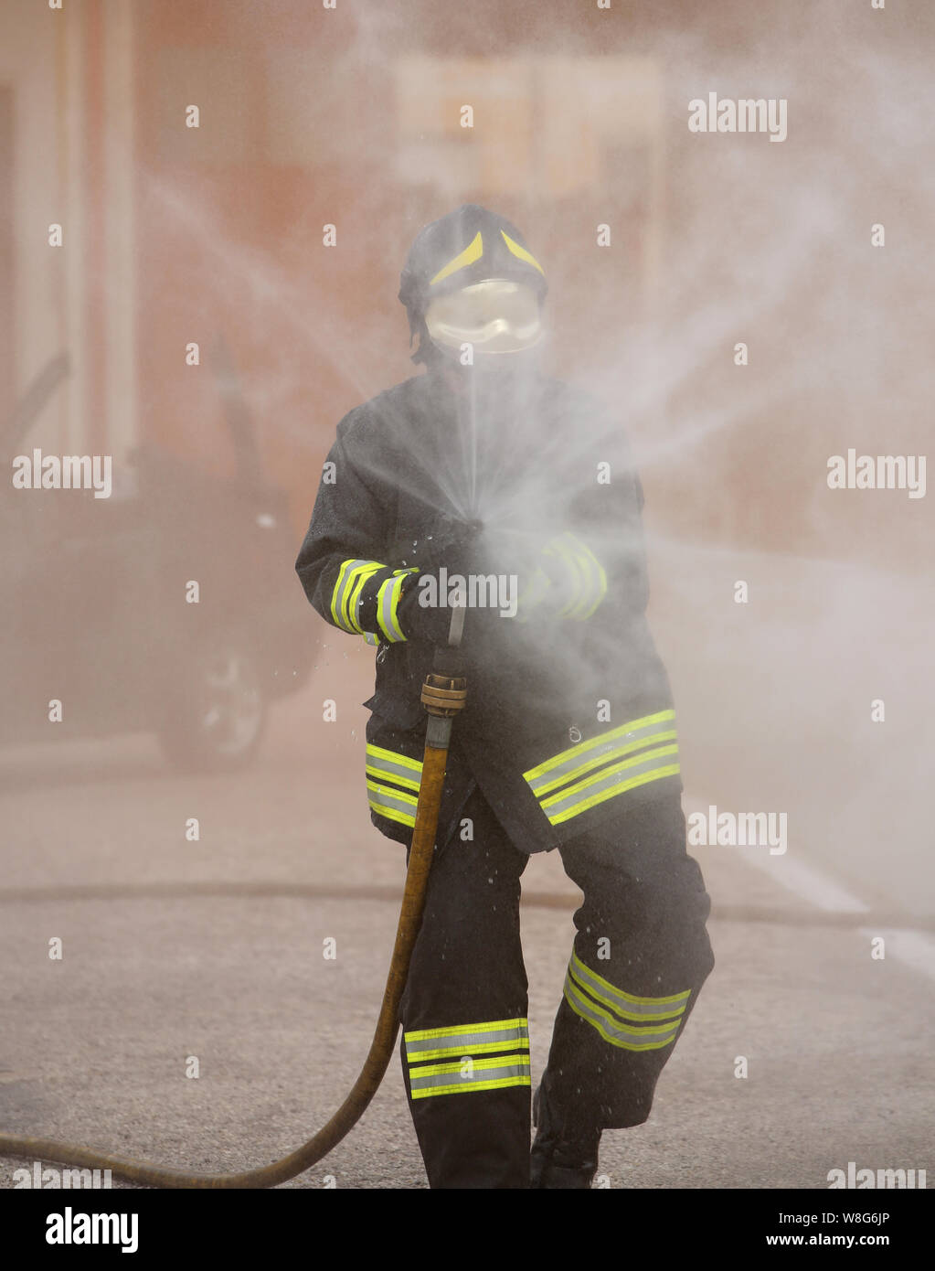brave firefighter in action with the foaming agent during an emergency ...