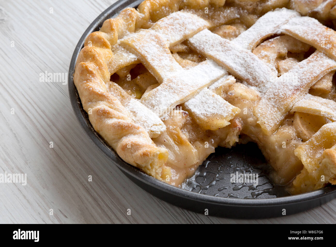 Home-baked apple pie on a white wooden background, side view. Close-up ...