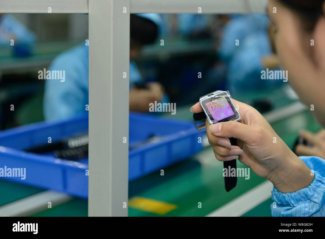 --FILE--A Chinese worker assembles a smart watch on the assembly line ...