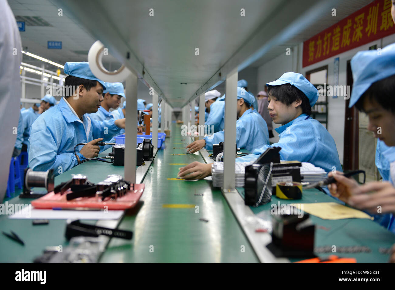 --FILE--Chinese workers assemble smart watches on the assembly line at ...