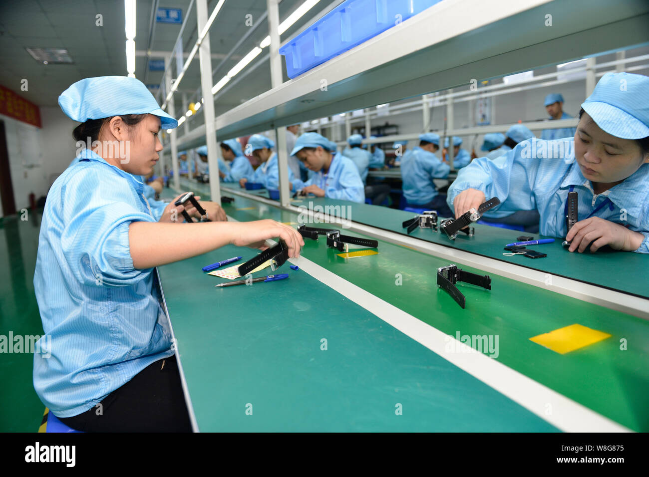 --FILE--Chinese workers assemble smart watches on the assembly line at ...