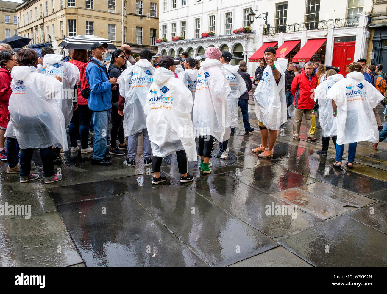Bath, Somerset, UK. 9th August, 2019. Tourists taking shelter under ...