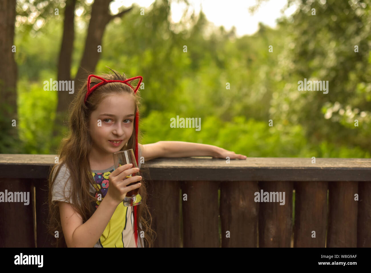 The girl wore a hoop cat ears and a red strand. A child walks in a cafe ...