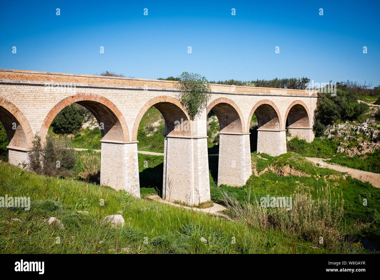 Beautiful old stone bridge of abandoned railway crossing a small river ...