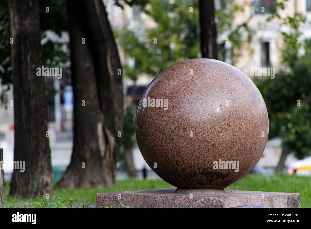 Architectural detail: a large stone ball on the sidewalk. Urban ...