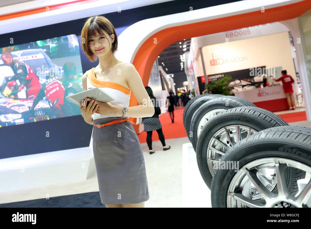 A hostess poses at the stand of Hankook during the 16th Shanghai ...