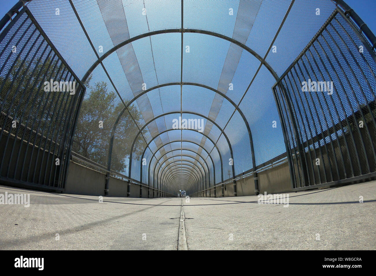 People walk across a pedestrian bridge at the Otay Mesa Port of Entry ...