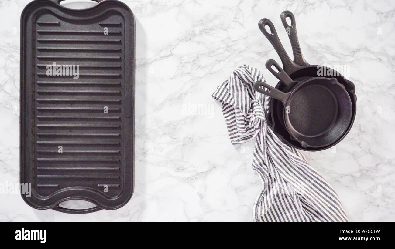 Flat lay. Variety of cast iron kitchenware on a marble countertop Stock ...