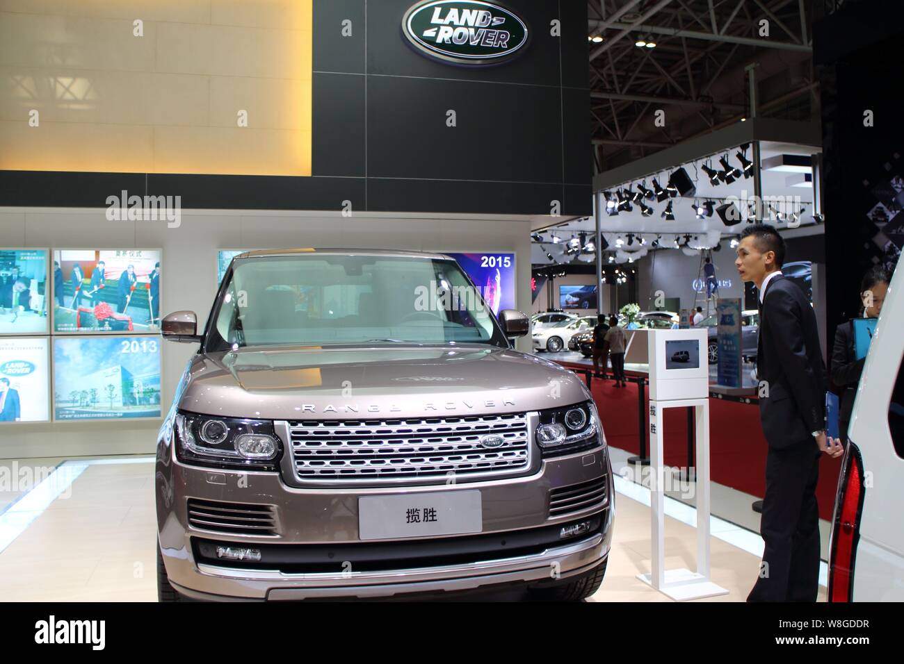 --FILE--A Chinese employee stands next to a Range Rover of Jaguar Land ...
