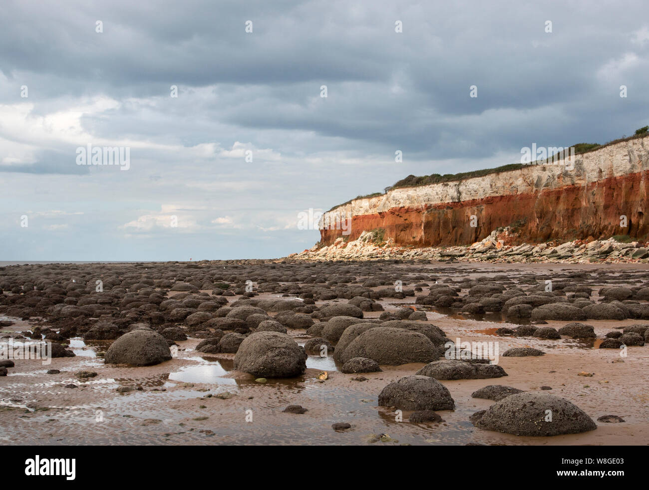 Hunstanton striped cliffs, with rounded boulders on the beach Stock ...