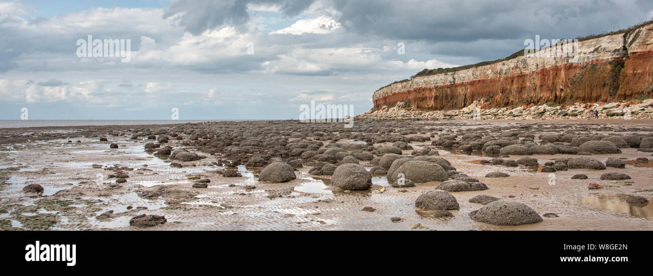 Hunstanton striped cliffs, with rounded boulders on the beach Stock ...
