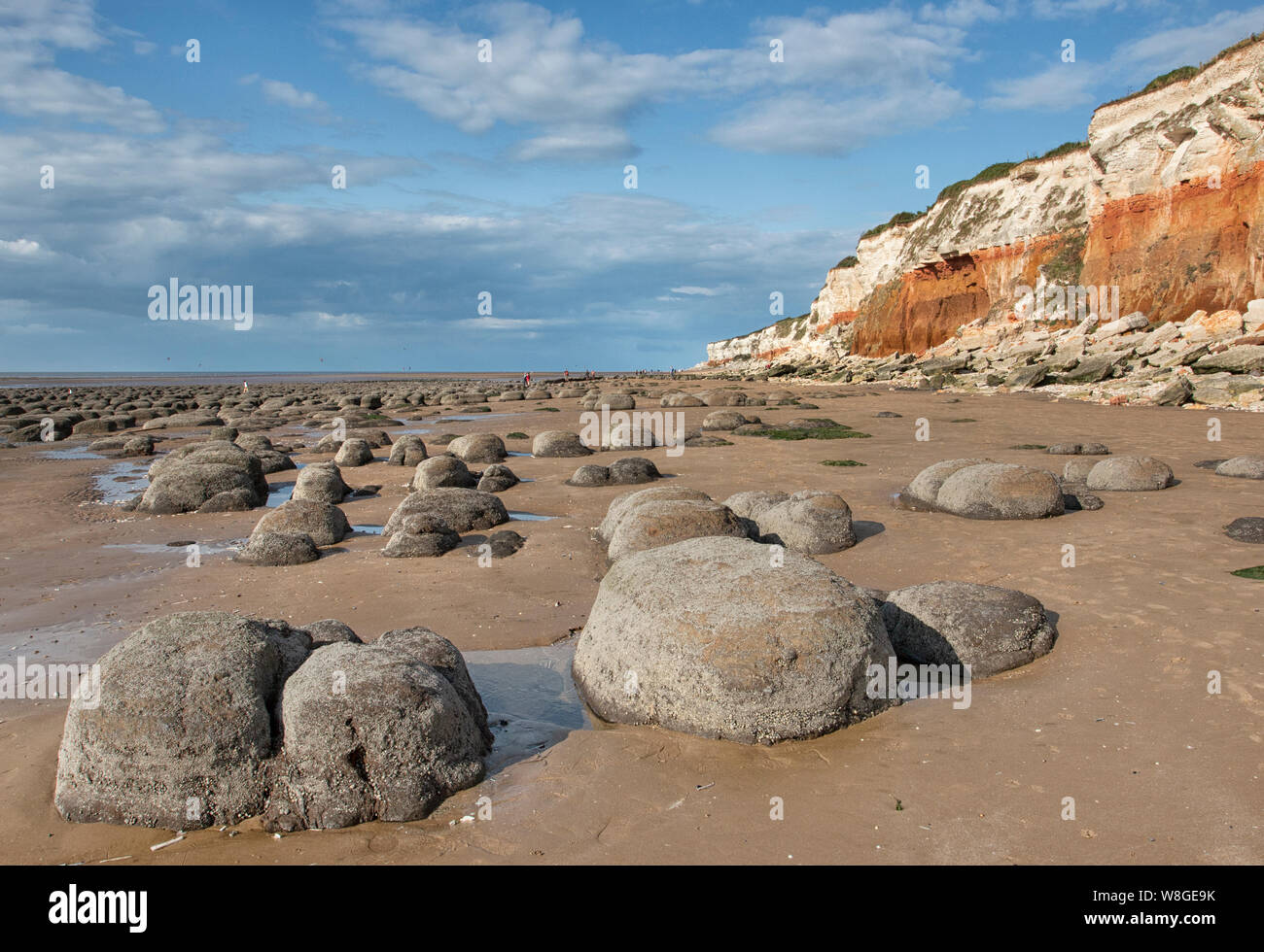 Hunstanton striped cliffs, with rounded boulders on the beach Stock ...