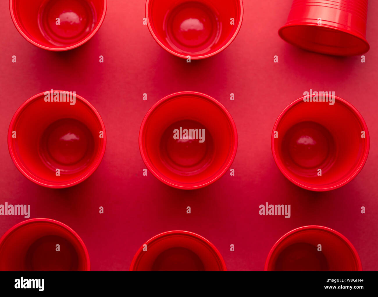 Drinking plastic disposable glasses on a red background Stock Photo - Alamy
