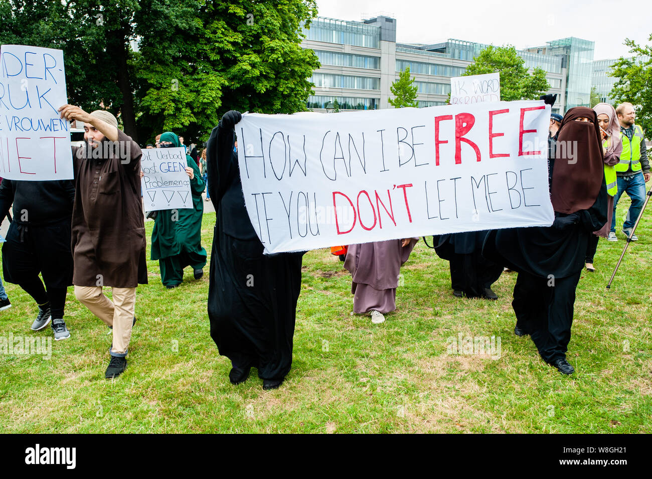 Women wearing a niqab hold a banner during the protest.Hundreds of ...