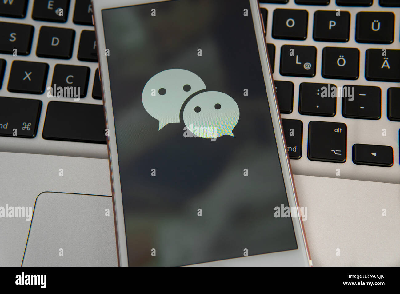 White iPhone with logo of social media WeChat on the screen. Social ...