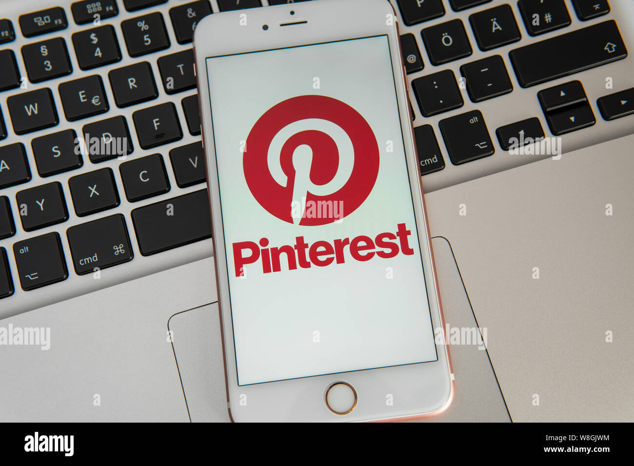 White iPhone with logo of social media Pinterest on the screen. Social ...