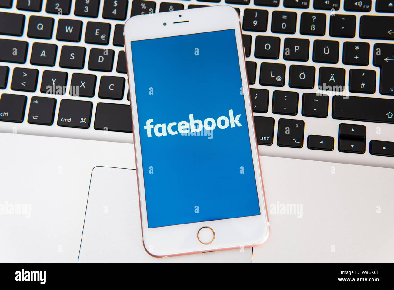 White iPhone with logo of social media Facebook on the screen. Social ...