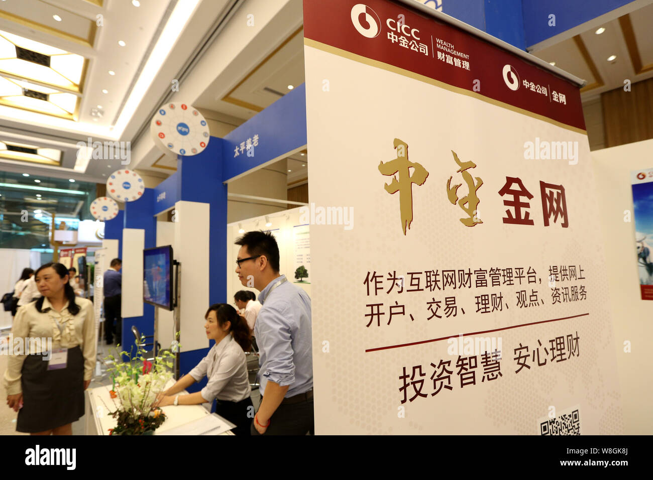 --FILE--Chinese employees are seen at the stand of CICC (China ...
