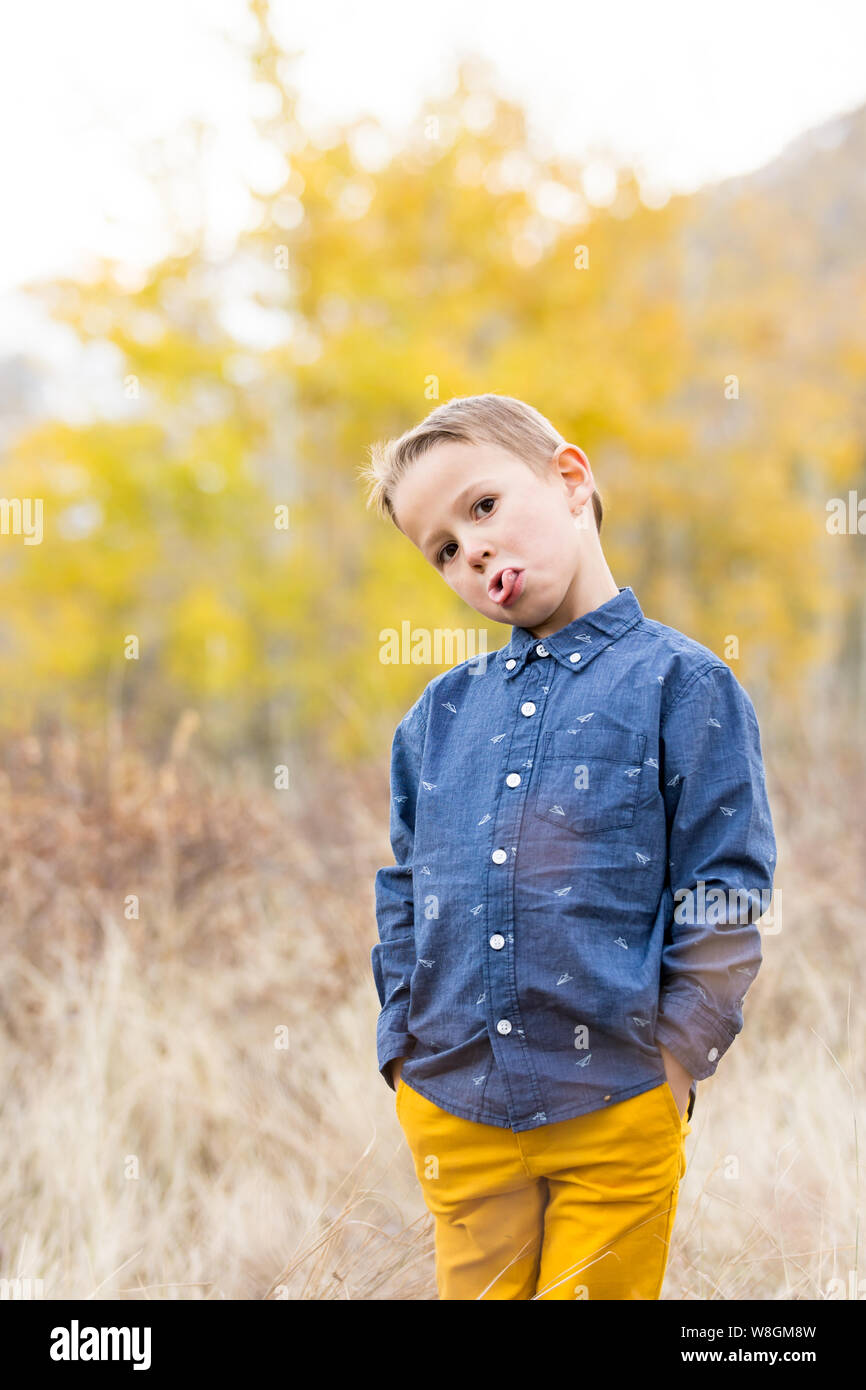 Young boy acts goofy for camera in beautiful autumn scene outdoors ...