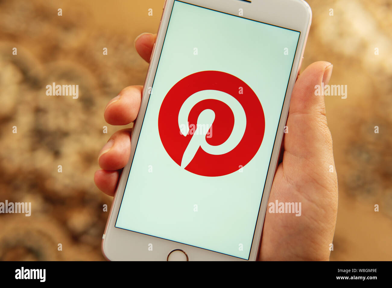 Female hand with Apple phone with logo of social media Pinterest on the ...