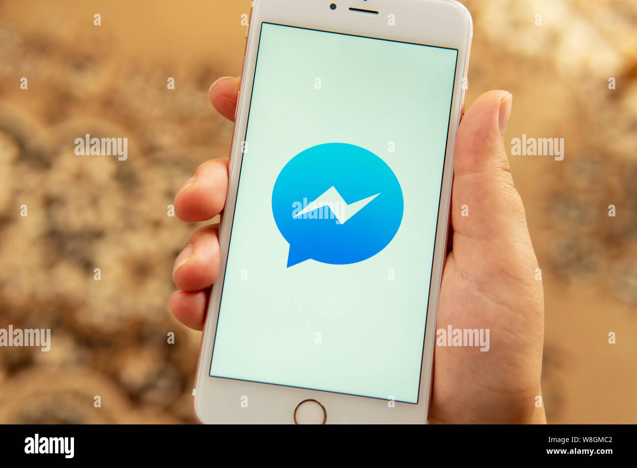 Female hand with Apple phone with logo of social media Facebook ...