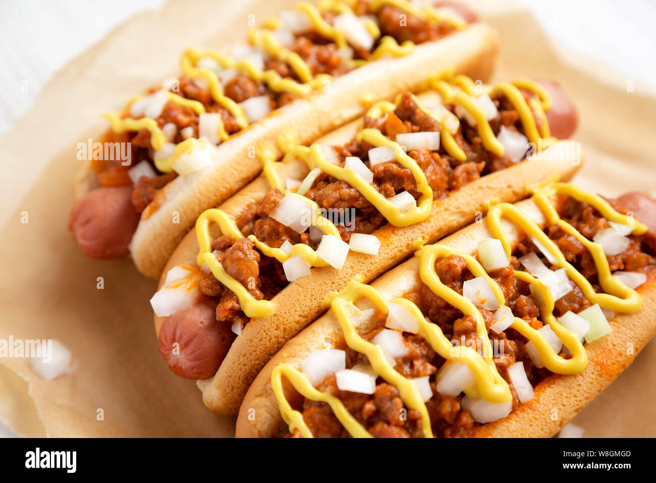 Homemade Detroit style chili dog on parchment, side view. Closeup Stock ...