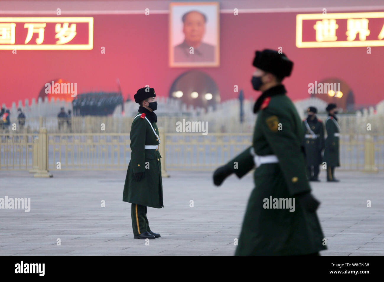 Chinese paramilitary policemen wearing face masks stand guard on the ...