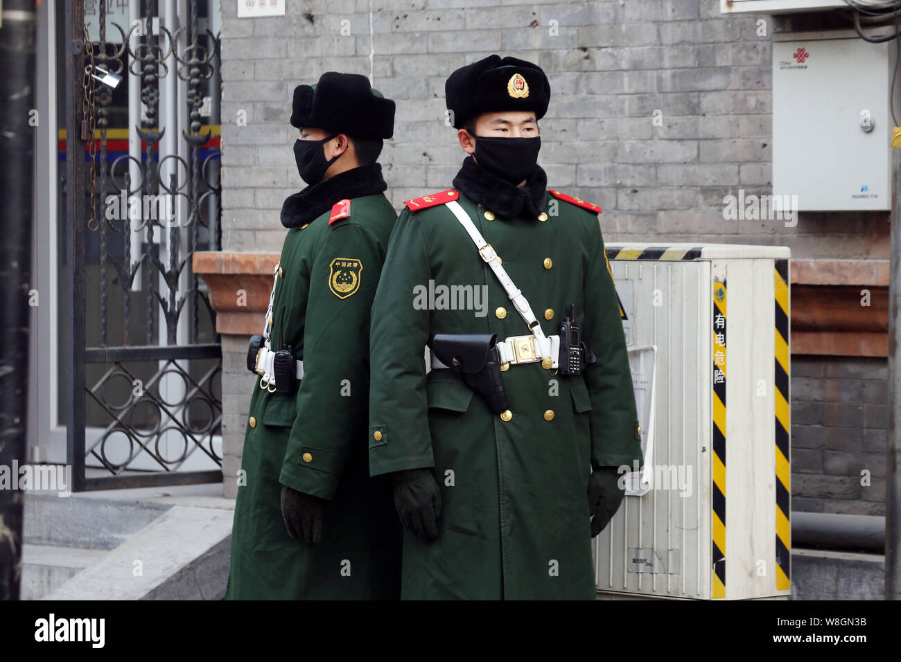Chinese paramilitary policemen wearing face masks stand guard near the ...
