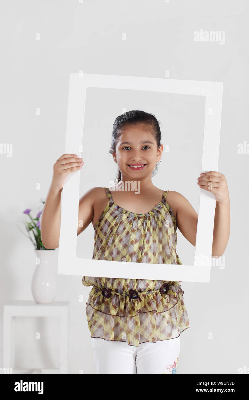 Girl holding a frame in front of her face Stock Photo - Alamy
