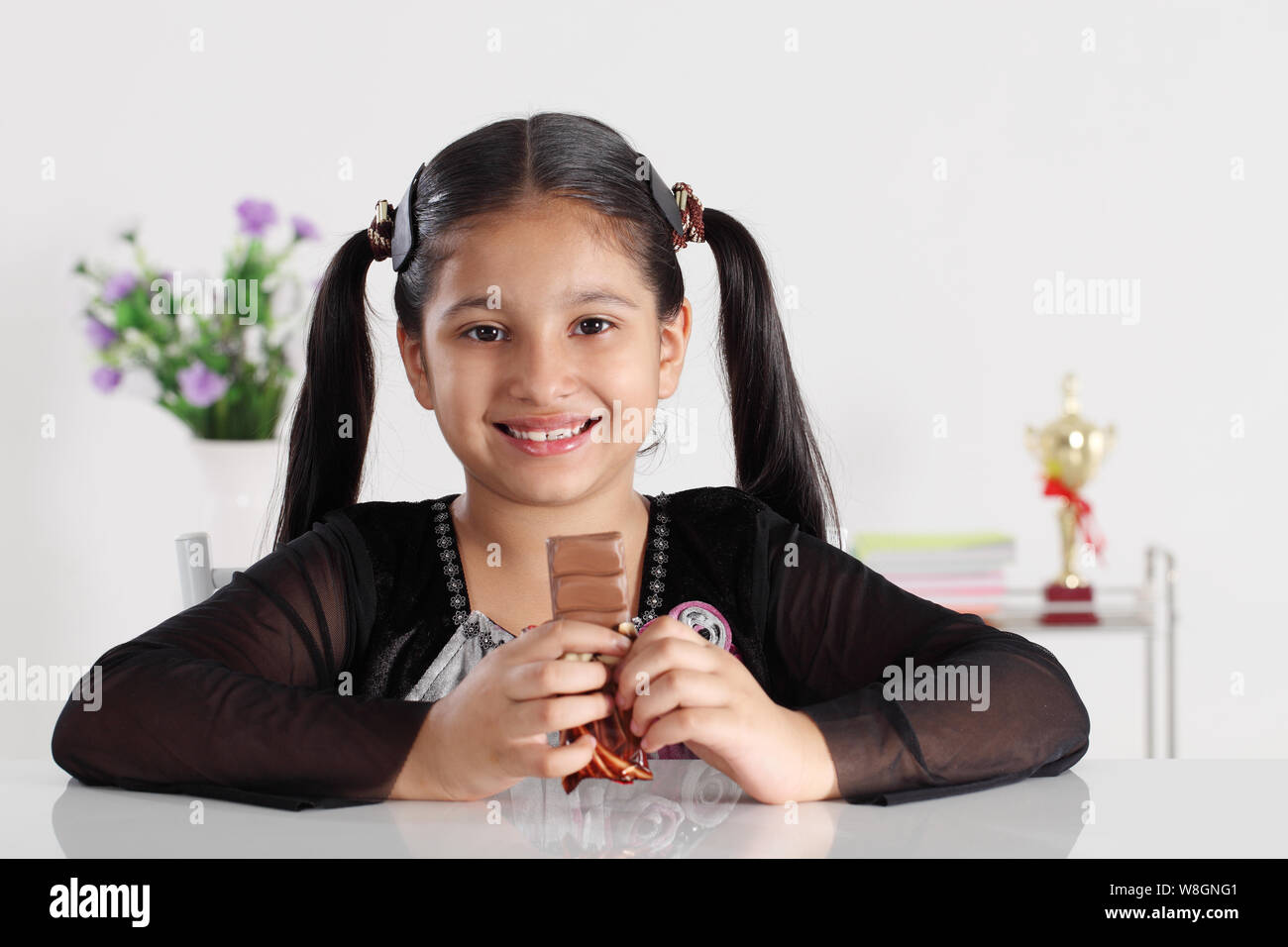 Girl eating chocolate bar Stock Photo - Alamy