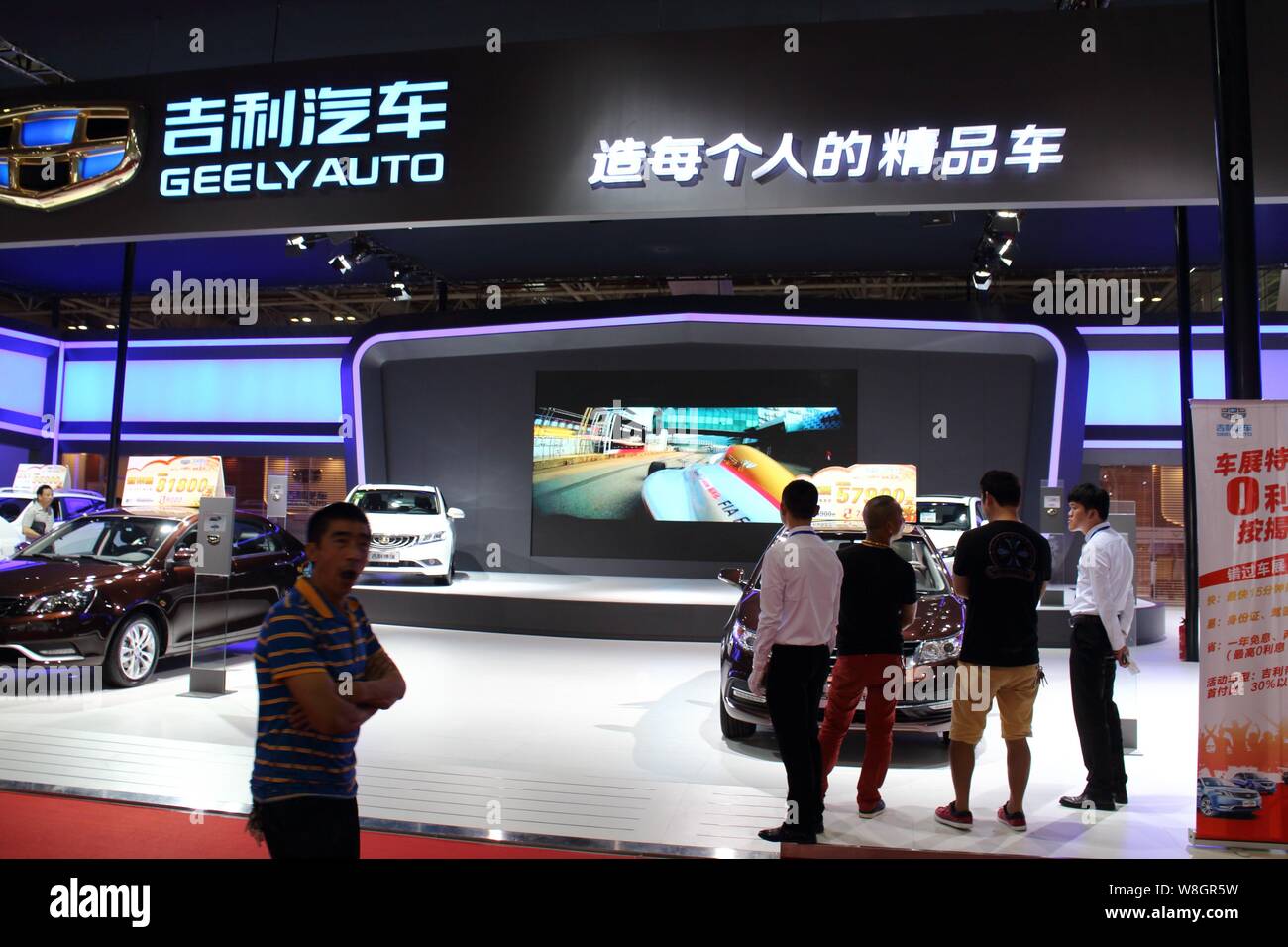 --FILE--People visit the stand of Geely during the 26th Chinese ...