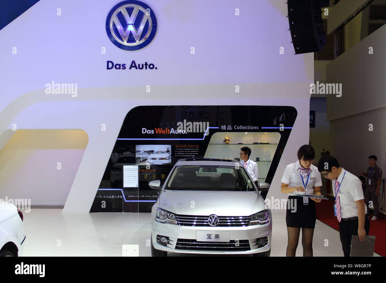 --FILE--Chinese employees stand next to a Bora of FAW Volkswagen, a ...