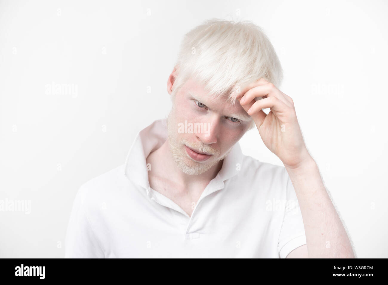 portrait of an albino man in studio dressed t-shirt isolated on a white ...